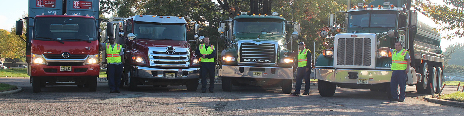 four trucks facing forward each with their driver standing by its side ...